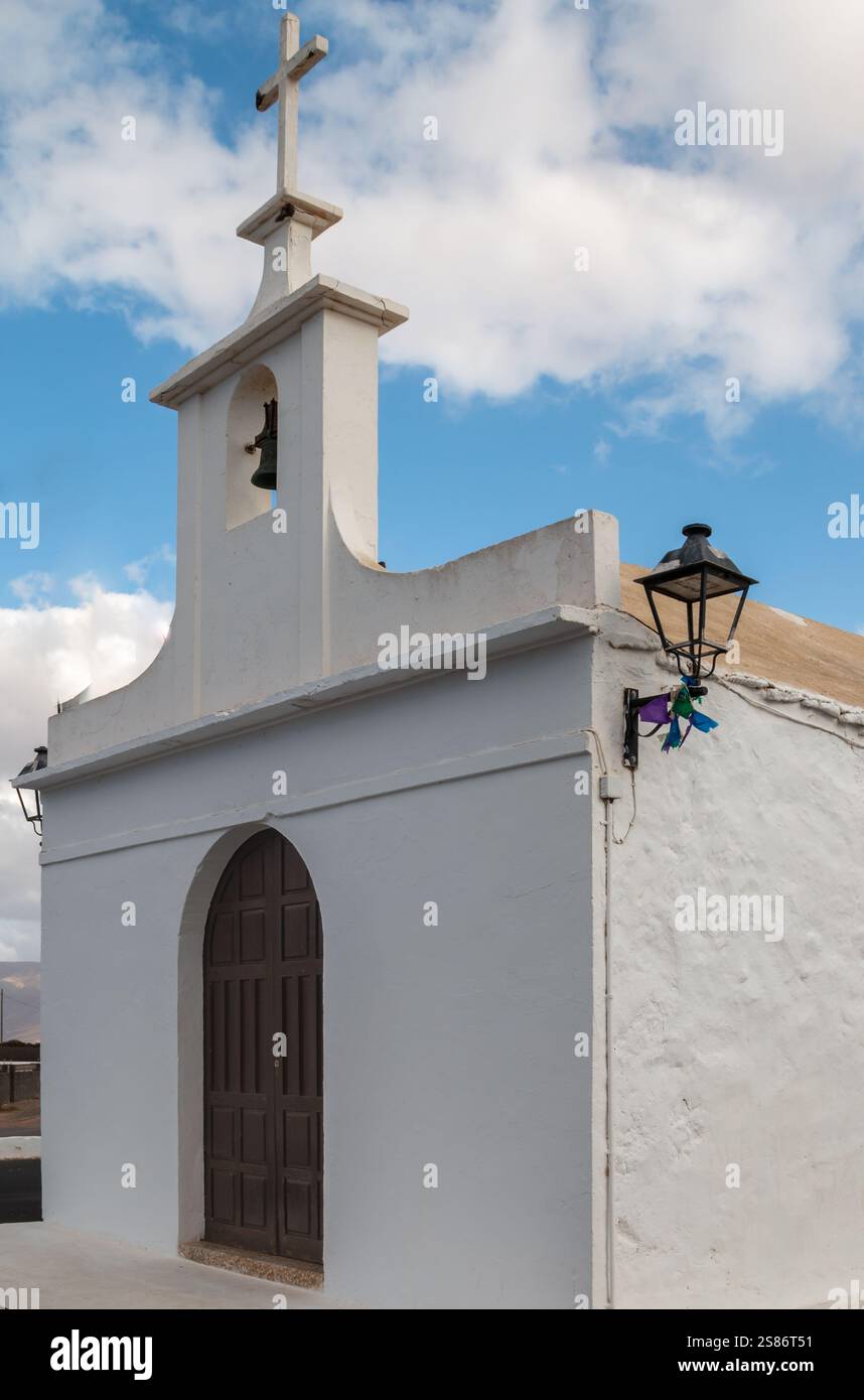 Traditional white facade of the architecture. Belfry and cross on the ...