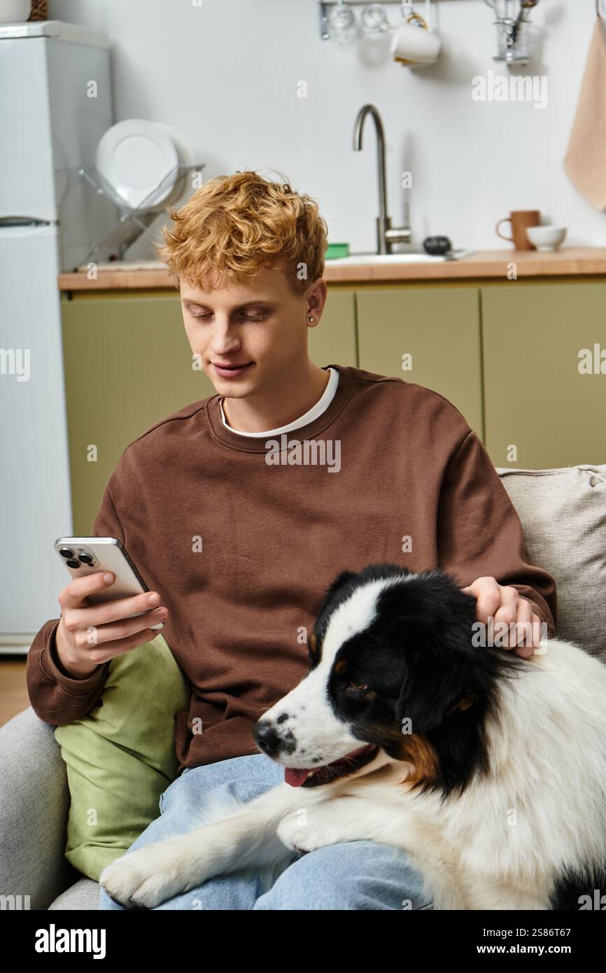 A red-haired young man relaxes at home with his adorable Australian ...