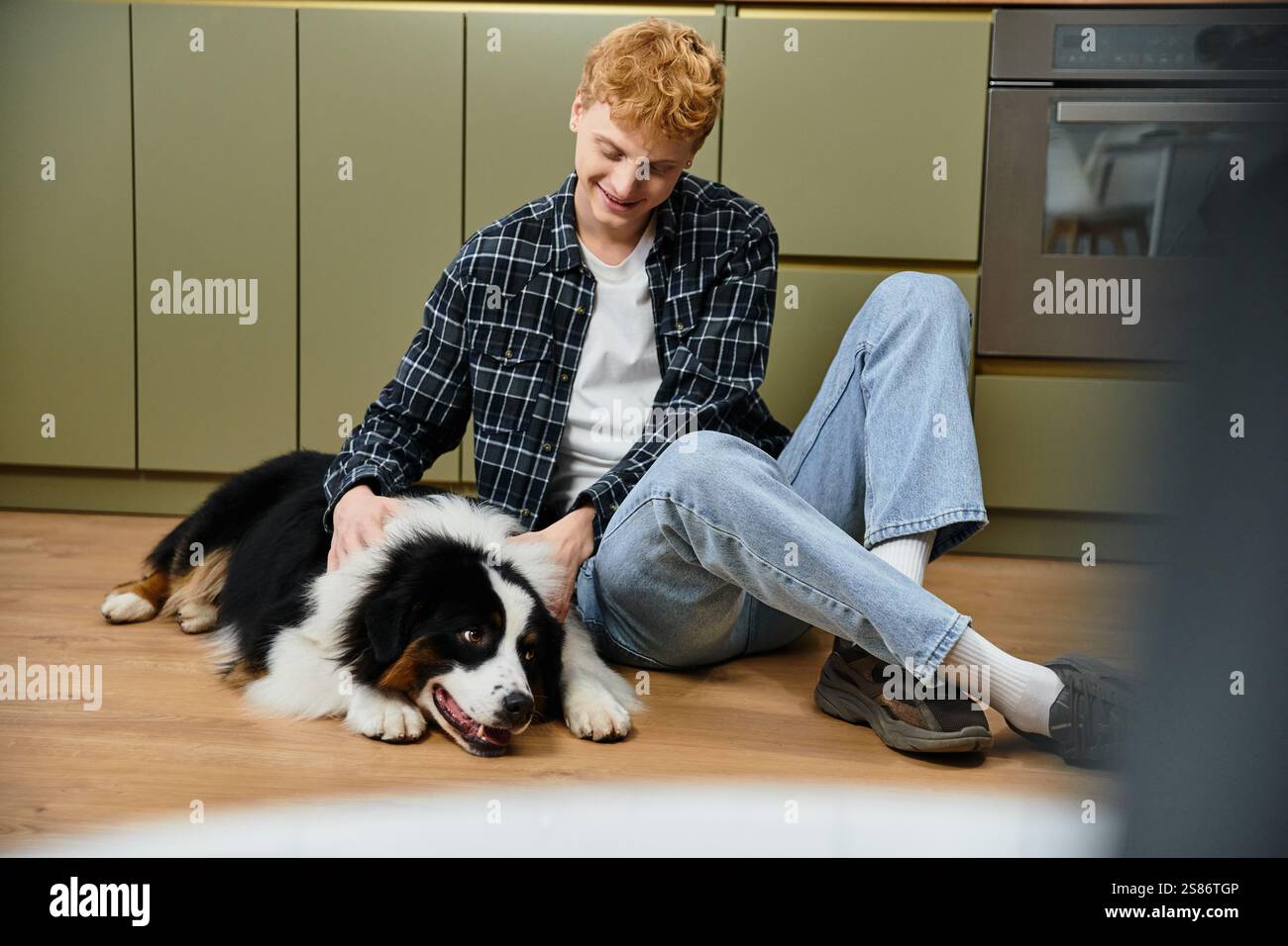 Young man interacts lovingly with his Australian Shepherd dog in a ...