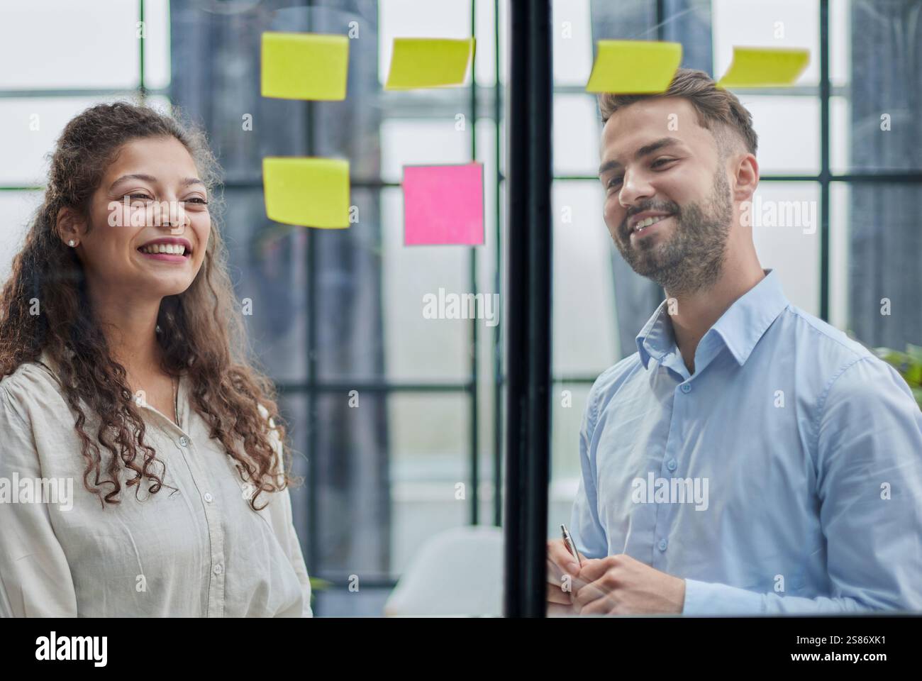 Business people talking in the hallway of the modern office building with employees working ...
