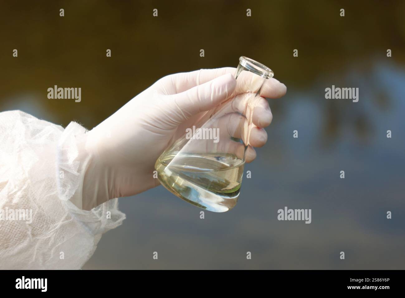 Examination of water quality. Researcher holding flask with sample ...