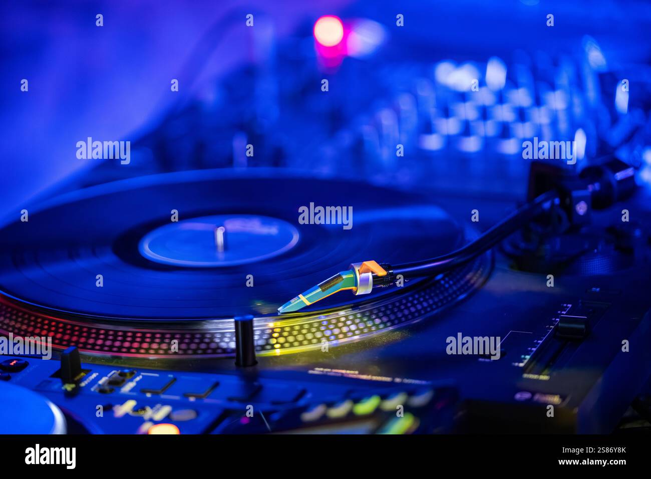 Turntable with vinyl record detail in low light picture. Vinyl record on turntable blue ...