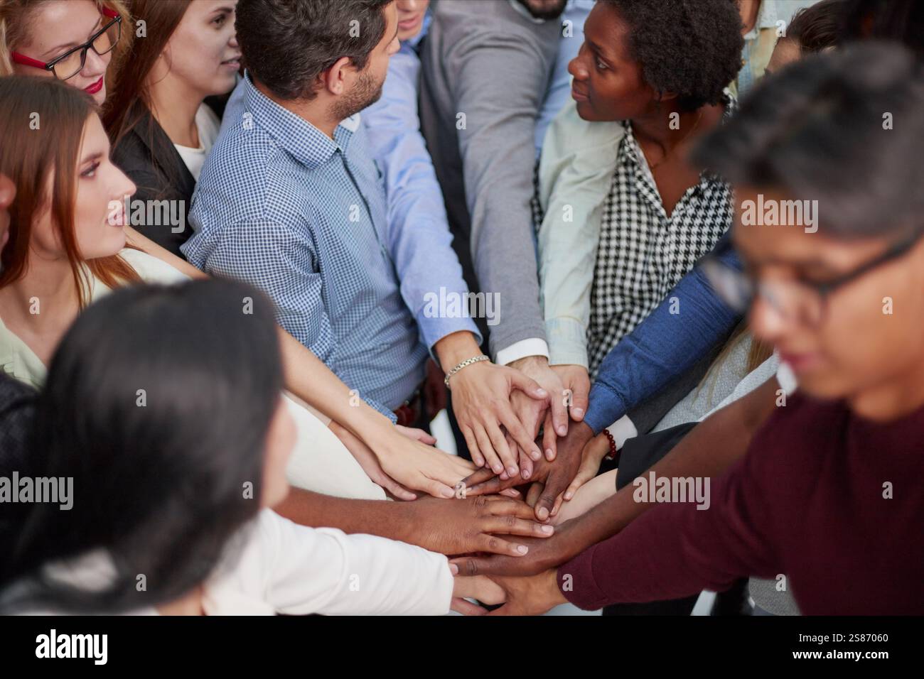 Multiethnic college students fold their hands in place Stock Photo - Alamy