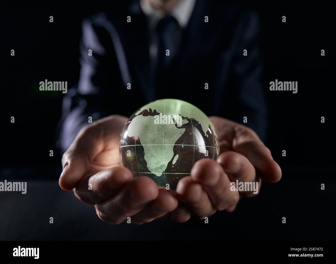 Man holding a glowing earth globe in his hands. Earth image provided by ...