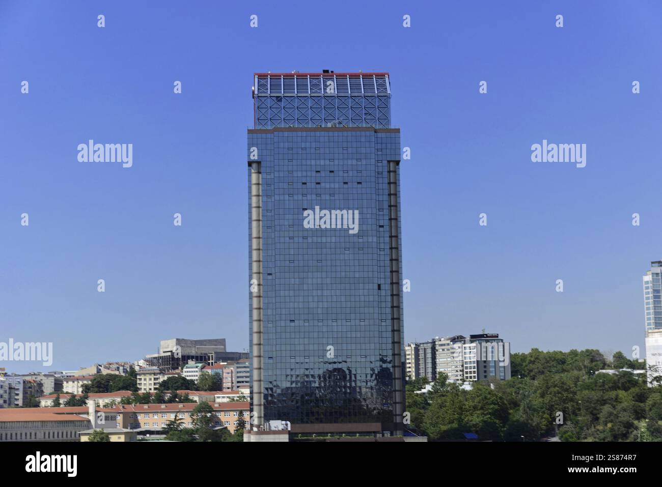 A modern skyscraper with a glass facade under a blue sky in a city ...