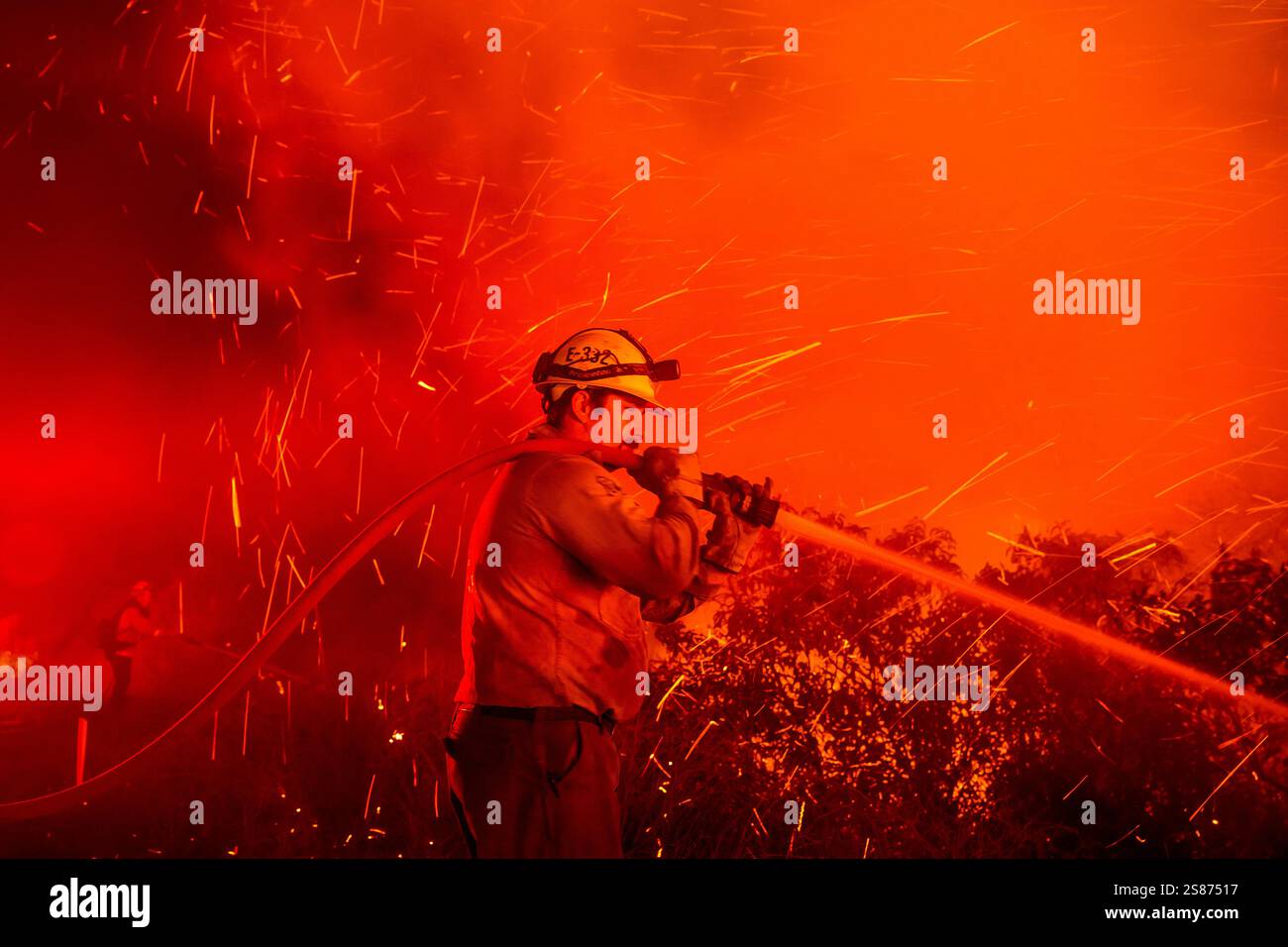 Firefighter Joshua Cari sprays water while battling the Lilac Fire near ...