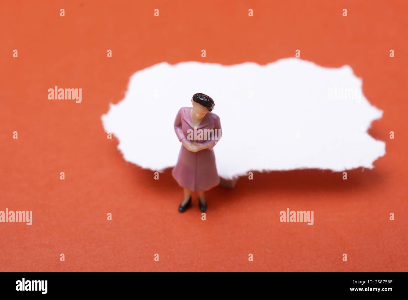 Human figurine beside white torn paper Stock Photo - Alamy