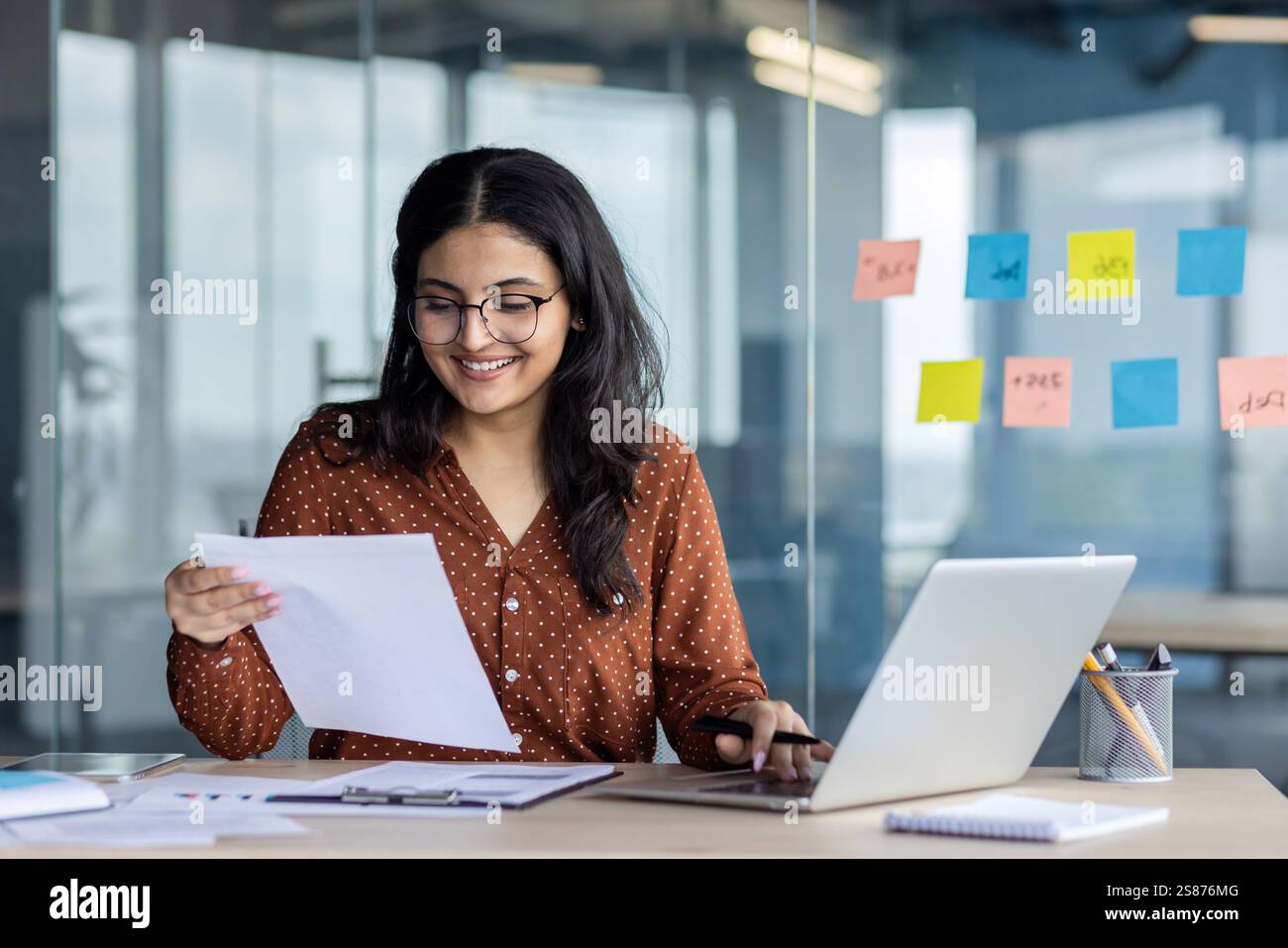 Paperwork office work, young successful latina woman working with documents and contracts inside ...