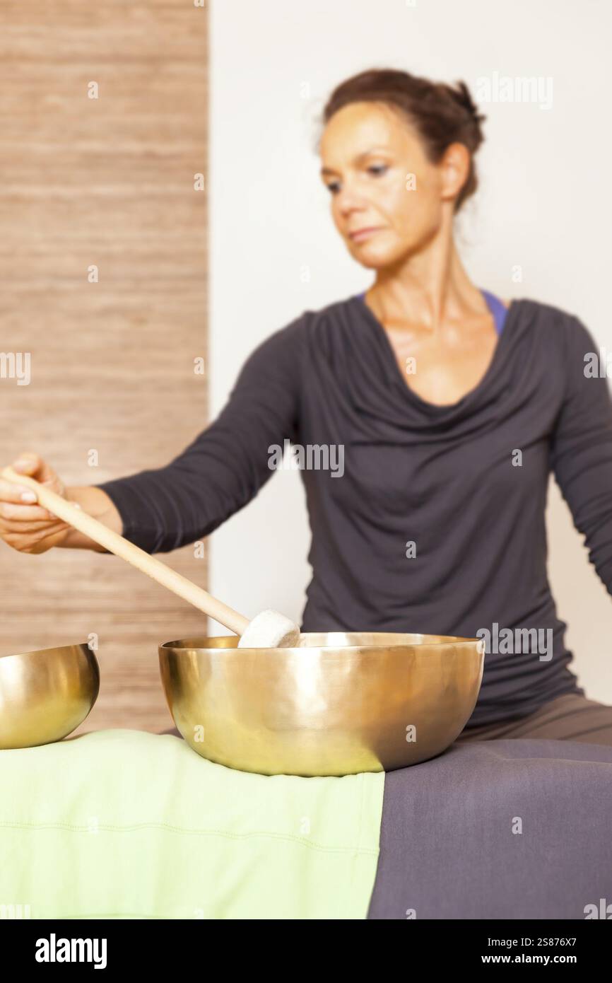 A woman is relaxing with singing bowls on her body Stock Photo - Alamy