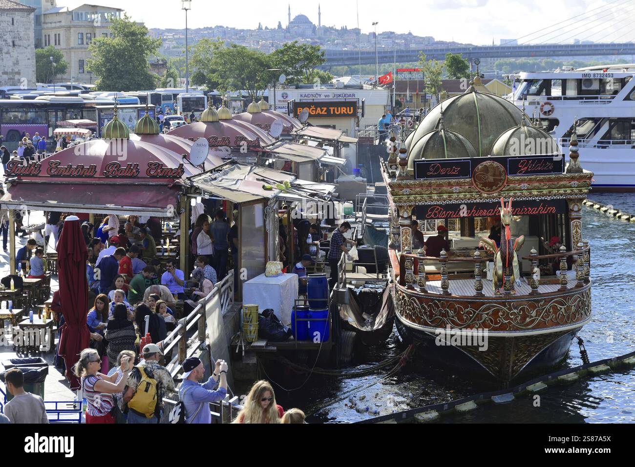 Lively harbour in Istanbul with many people and traditional boats ...