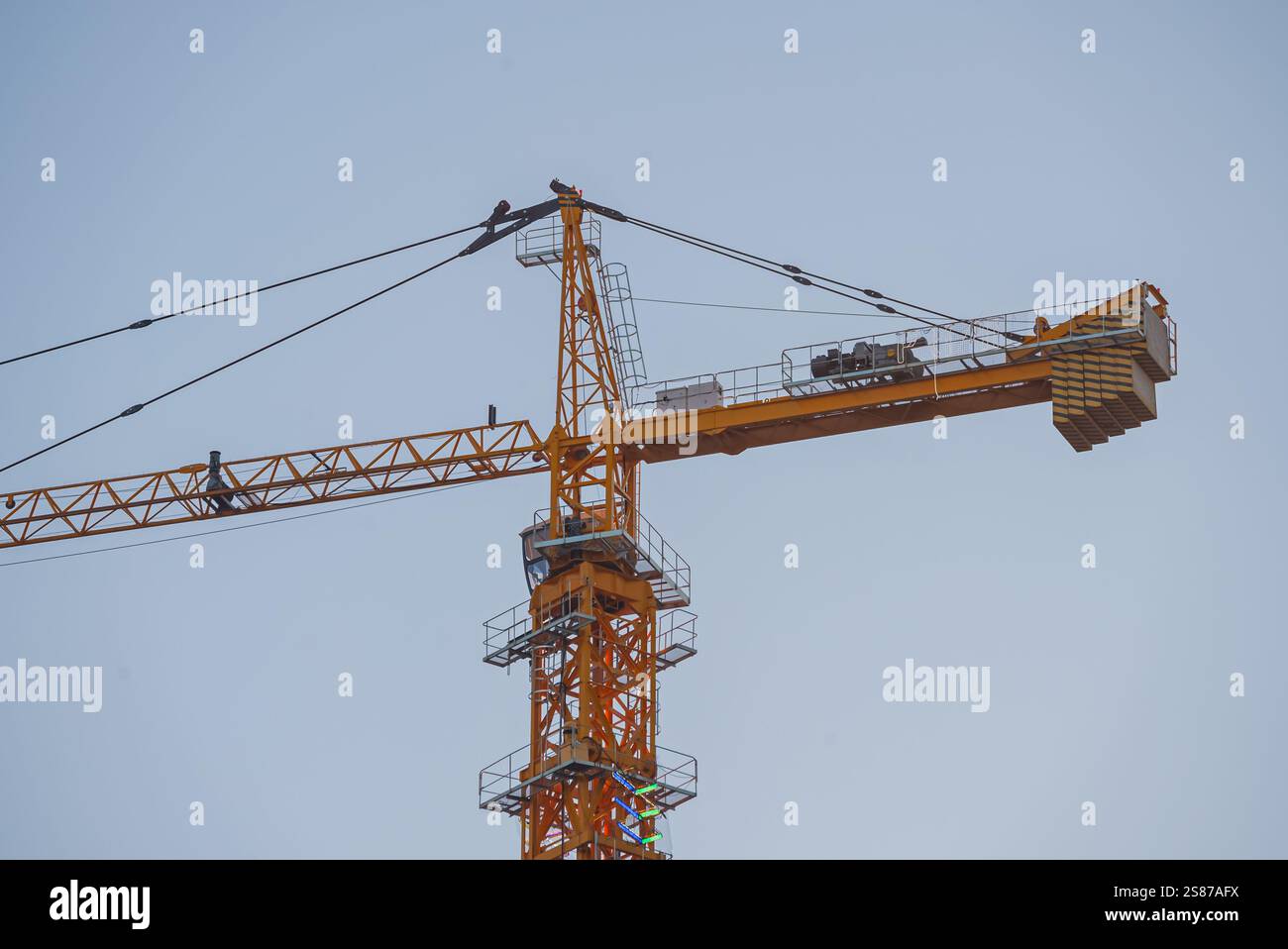 Tower crane lifting building materials at construction site with clear ...