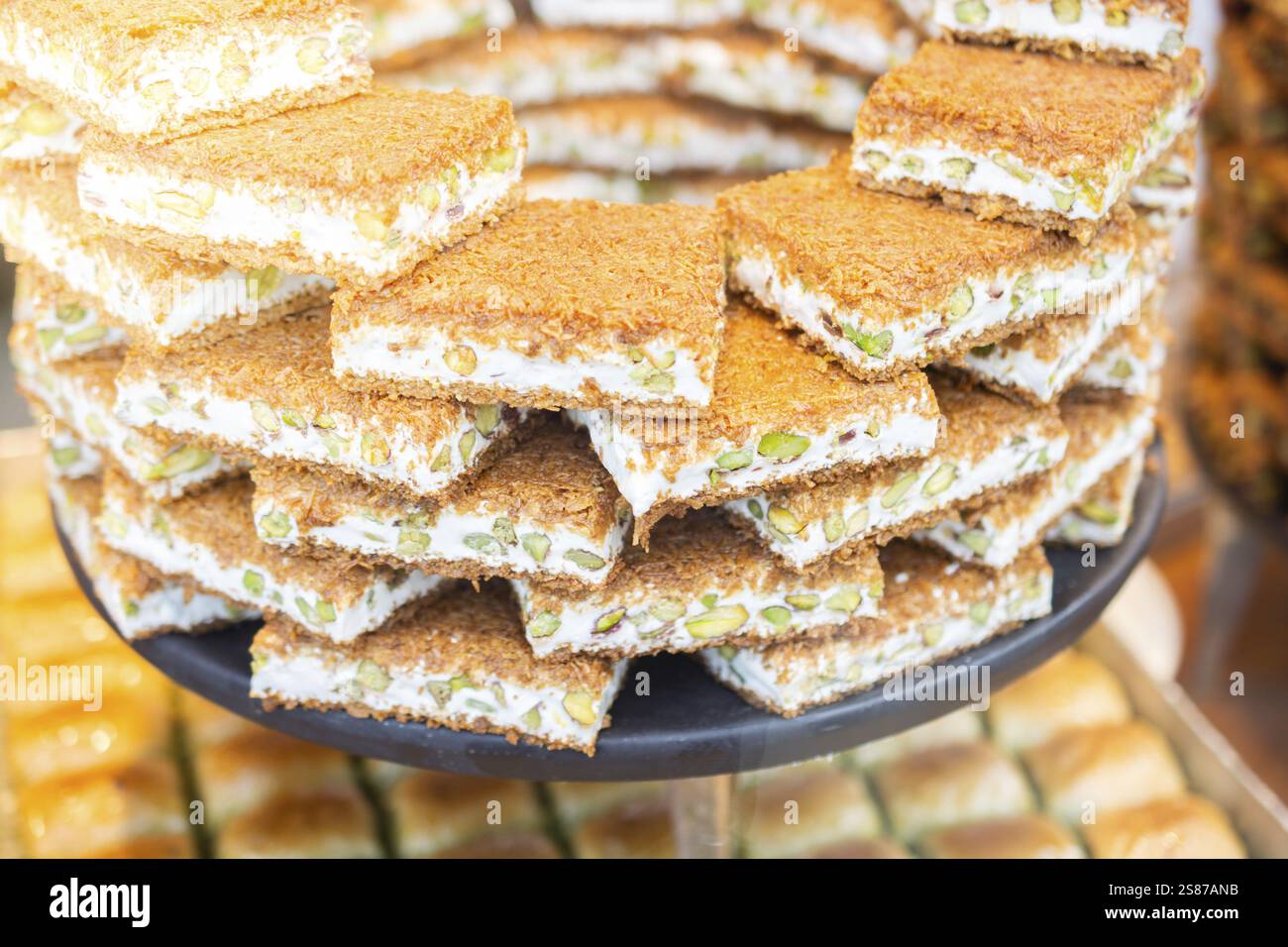 Turkish traditional dessert Kadayif baked in syrup served with nut ...