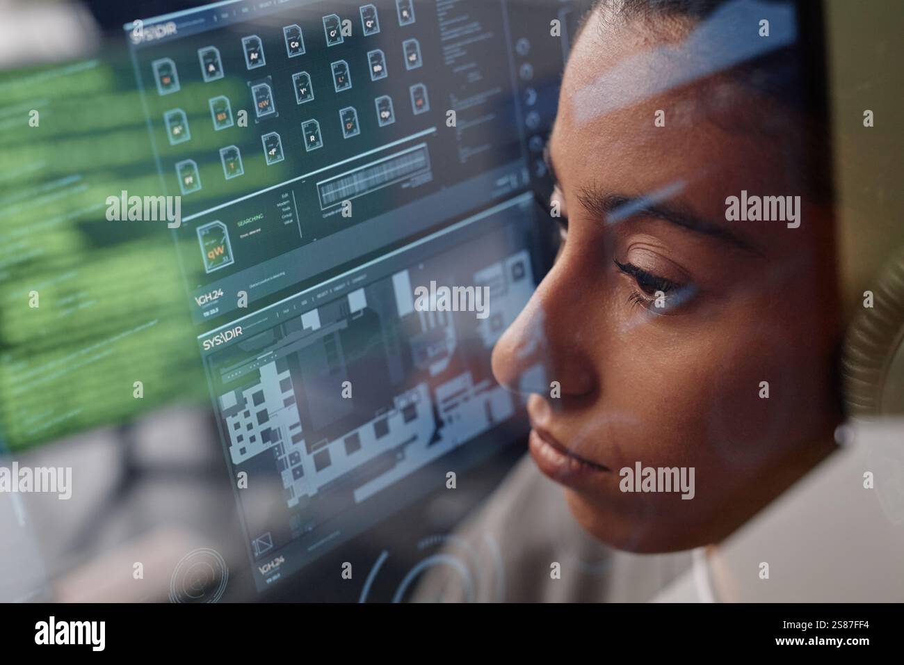 Extreme close up of concentrated Middle Eastern female programmer looking at computer screen ...