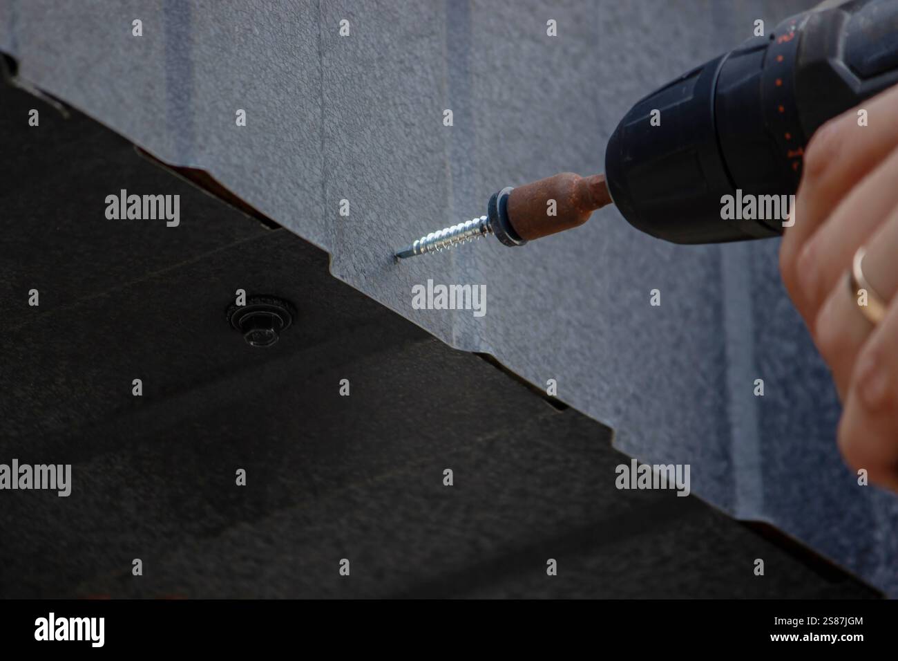 Man Installing Roof Panels with a Drill Stock Photo - Alamy