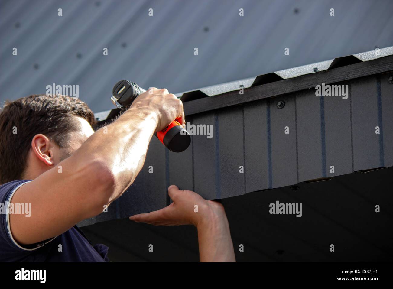 Man Installing Roof Panels with a Drill Stock Photo - Alamy