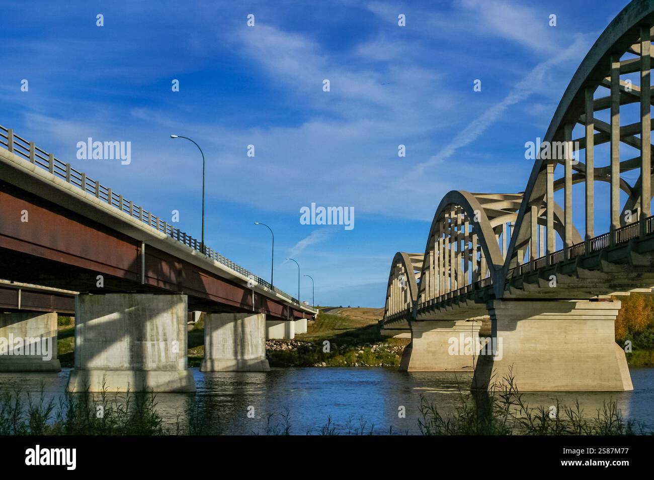 Two bridges over a river with a blue sky in the background. The bridge ...