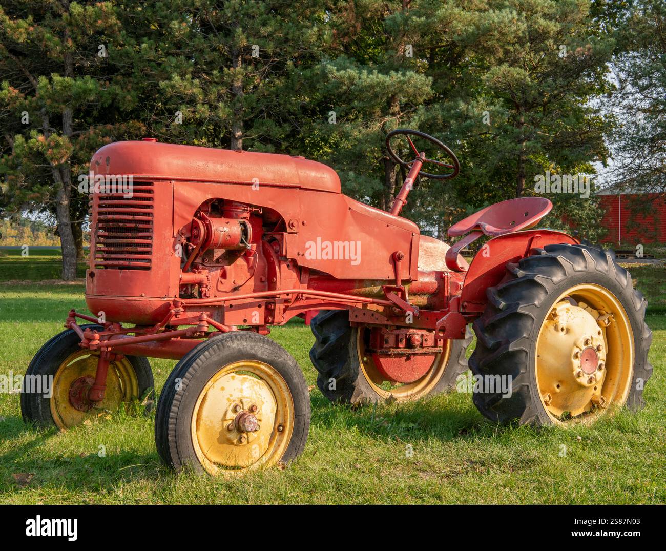 An old red farm tractor rusty and weathered in the field Stock Photo ...