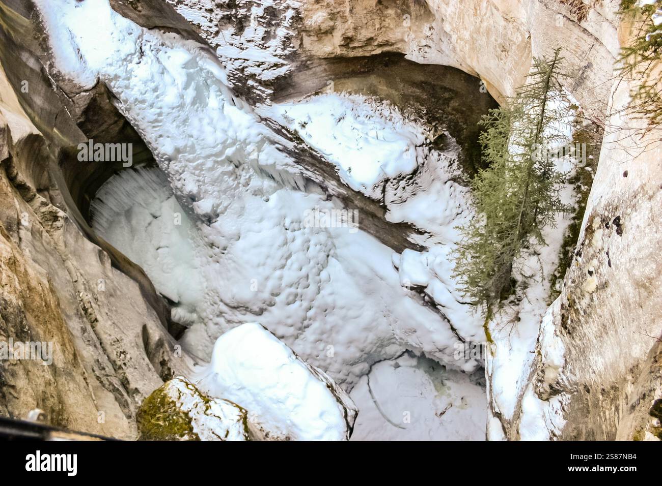 A snow covered mountain with a large hole in the middle. Trees are ...