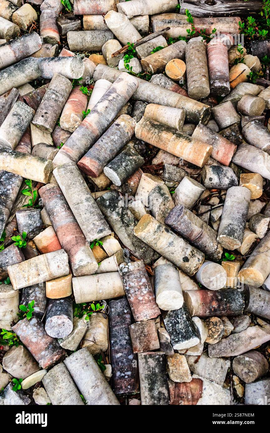 A pile of rock drill core from mining. The pile is made up of many ...