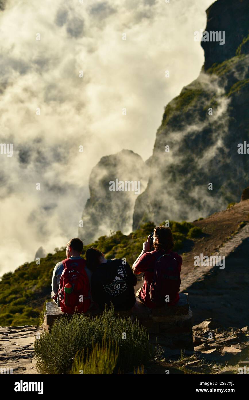 Hikers on trail pathway along jagged volcanic cliffs on Pico Areeiro ...