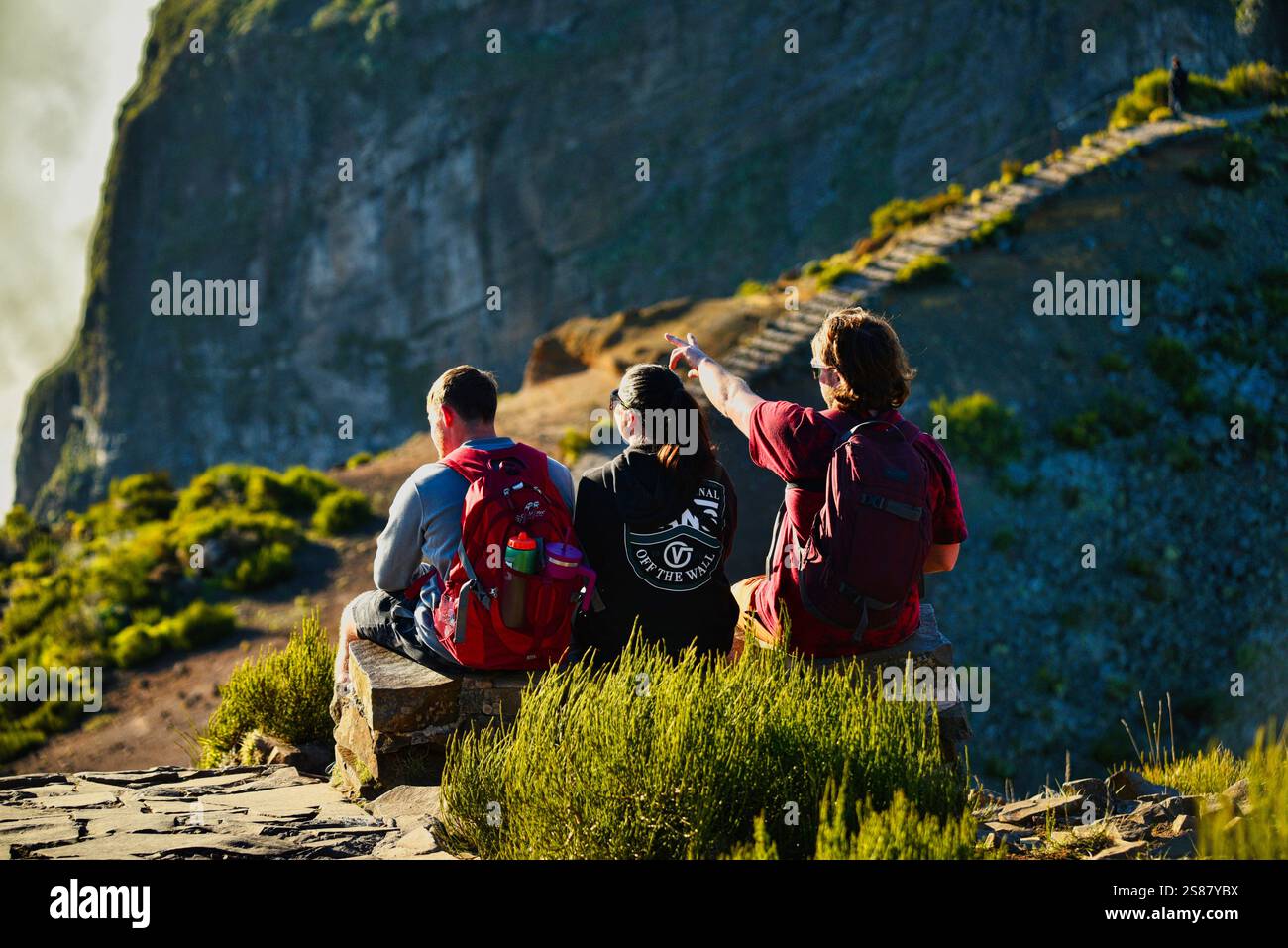 Hikers on trail pathway along jagged volcanic cliffs on Pico Areeiro ...