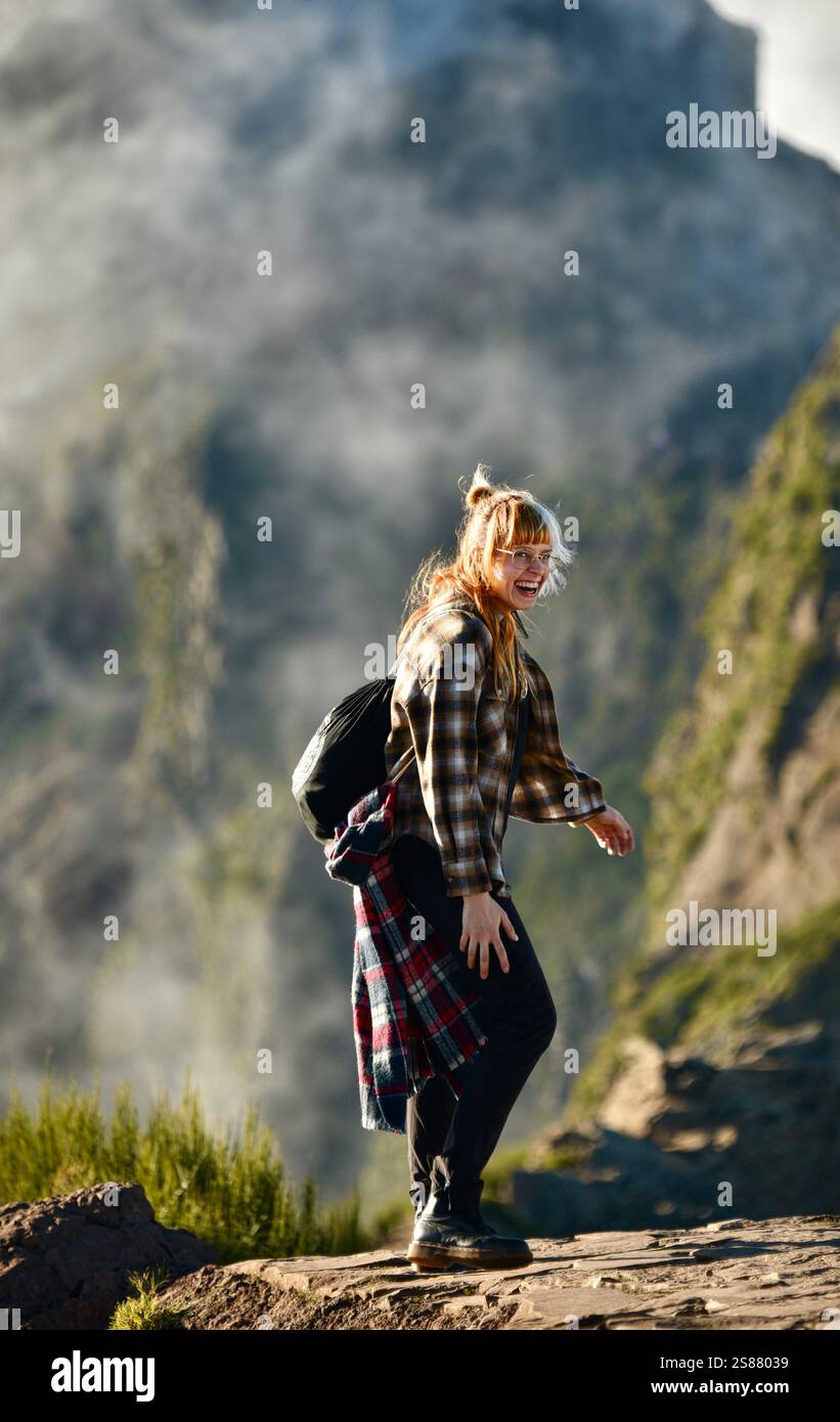 Hikers on trail pathway along jagged volcanic cliffs on Pico Areeiro ...