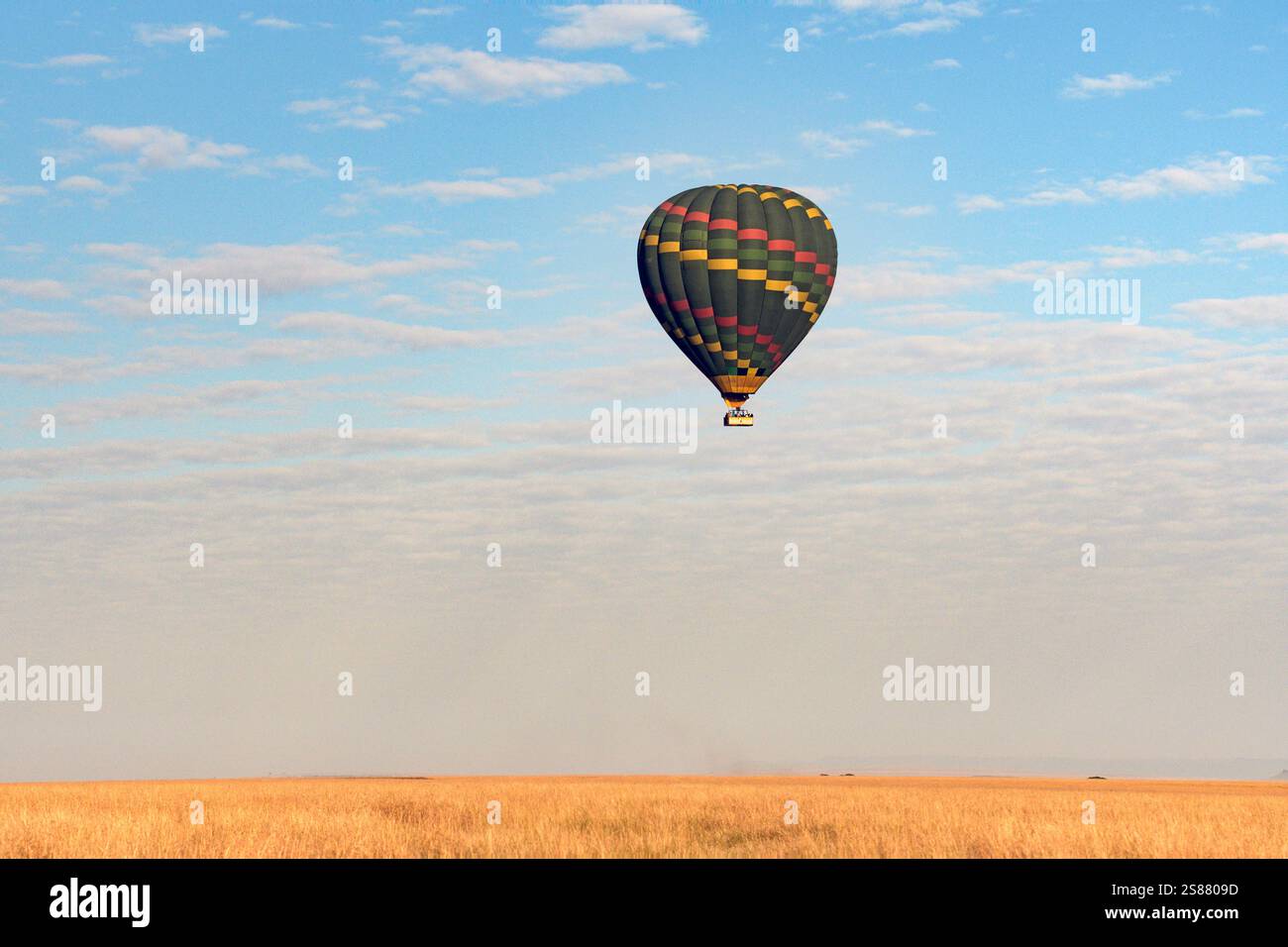 Hot-air balloon drifting in the sky over the savanna of Maasai Mara ...