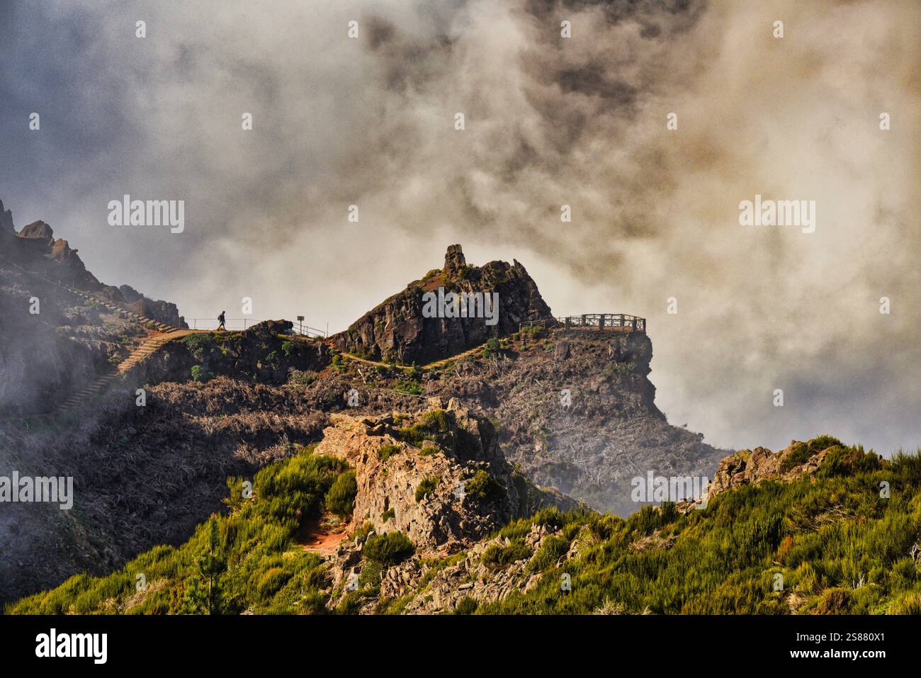 Hikers on trail pathway along jagged volcanic cliffs on Pico Areeiro ...