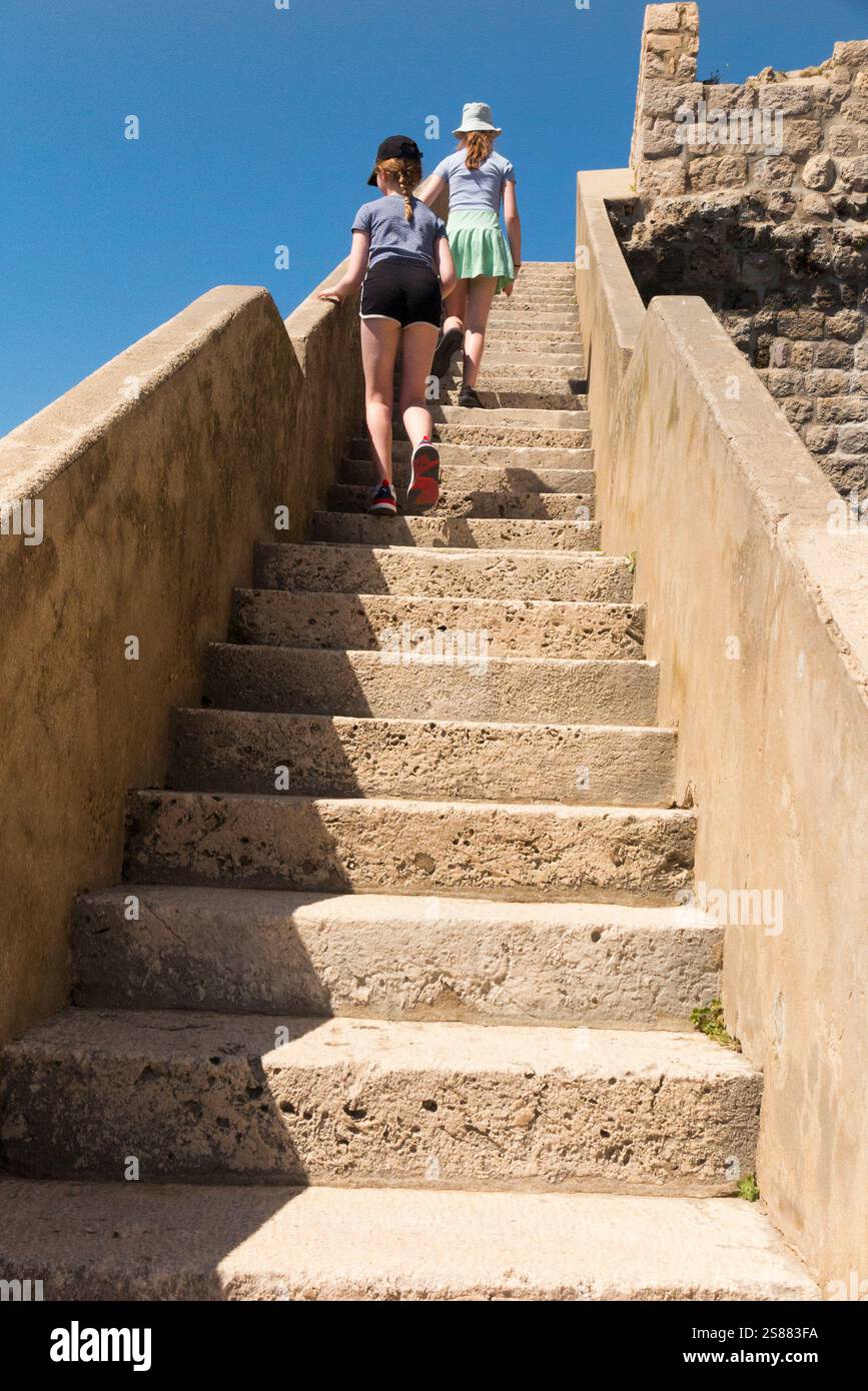 Children / kids climb stone steps / stairs on historic city wall ...