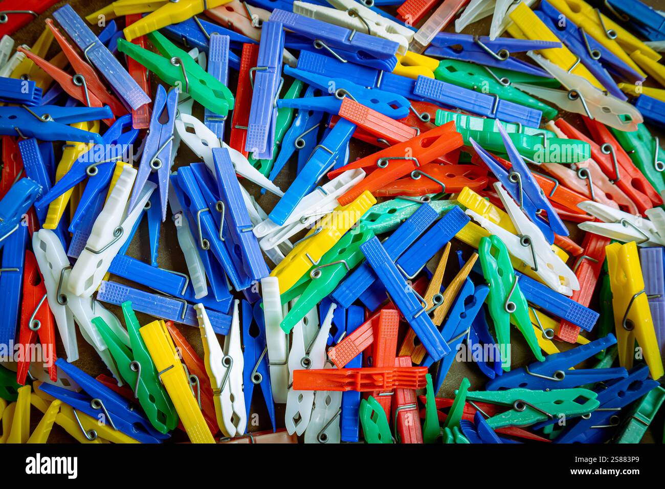 A pile of brightly colored plastic clothes pegs, used to hang washed ...