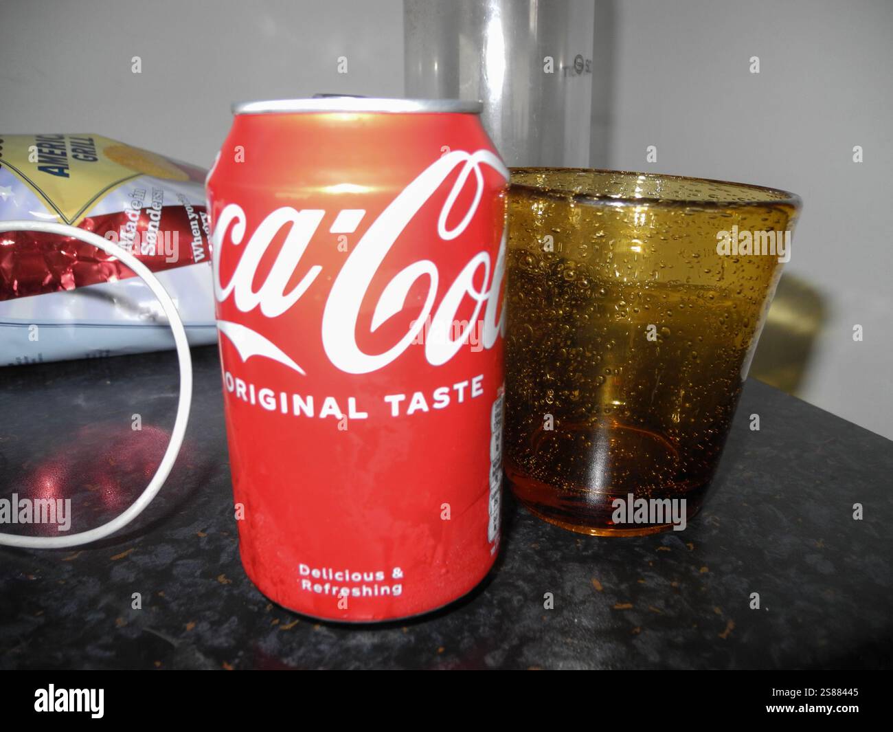 A Coca-Cola can and an empty glass seen at the counter Stock Photo - Alamy