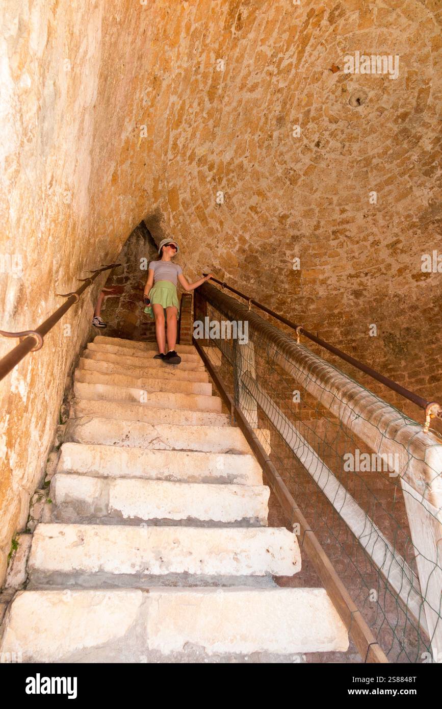 Child / kid / girl climbs down / descends interior steps leading up ...