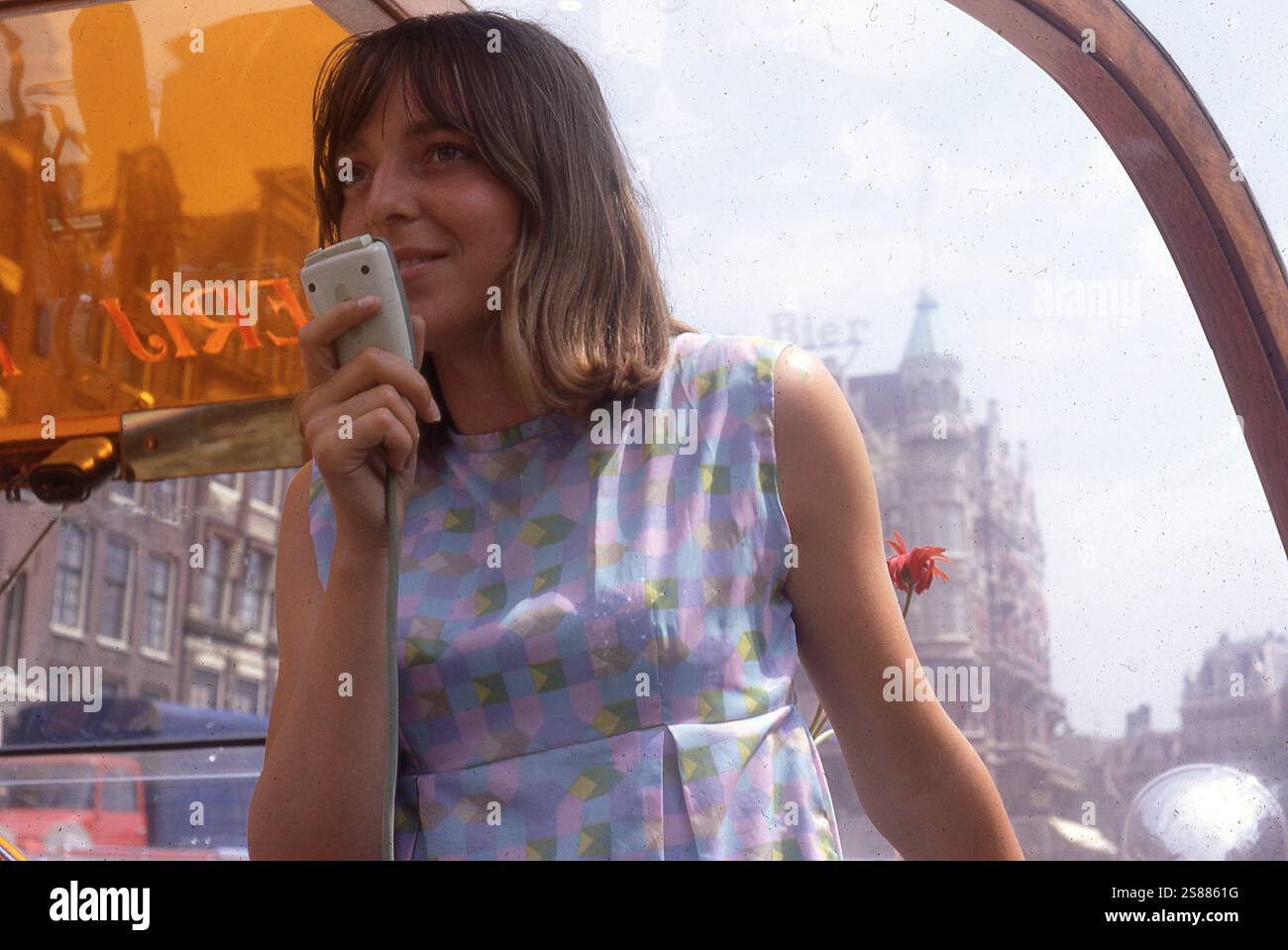 1970s, a pretty young woman on an open air city tourist bus with ...