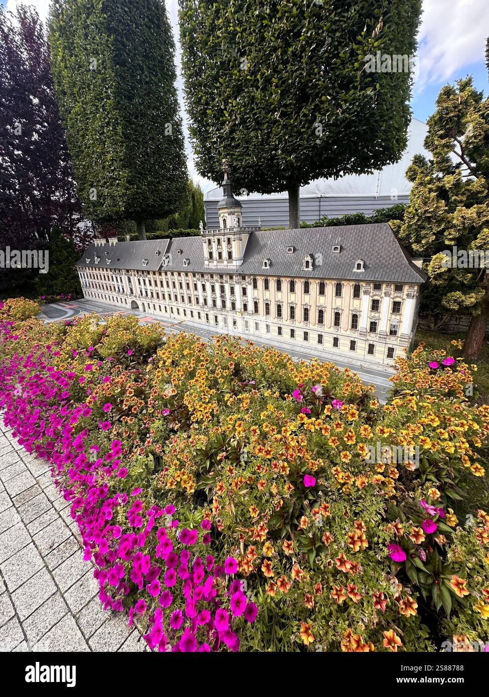 Miniature replicas of famous buildings surrounded by vibrant flowers ...