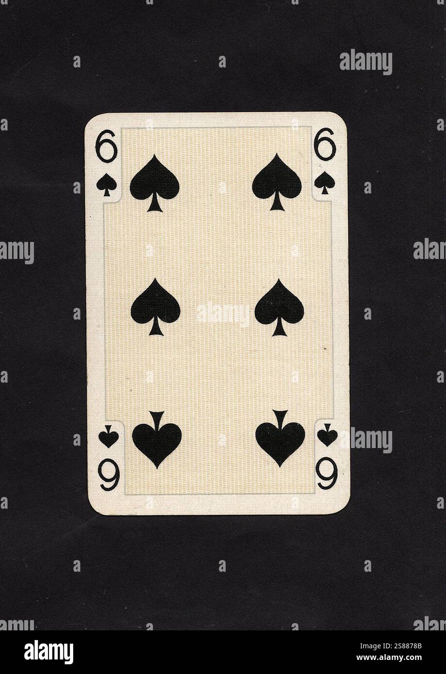 An antique six of spades playing card isolated on a black background ...