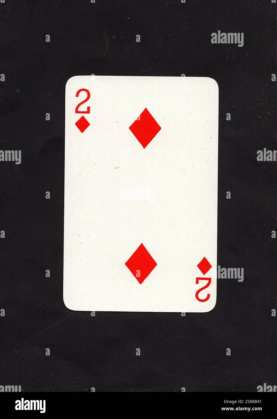 A vintage two of diamonds playing card isolated on a black background ...