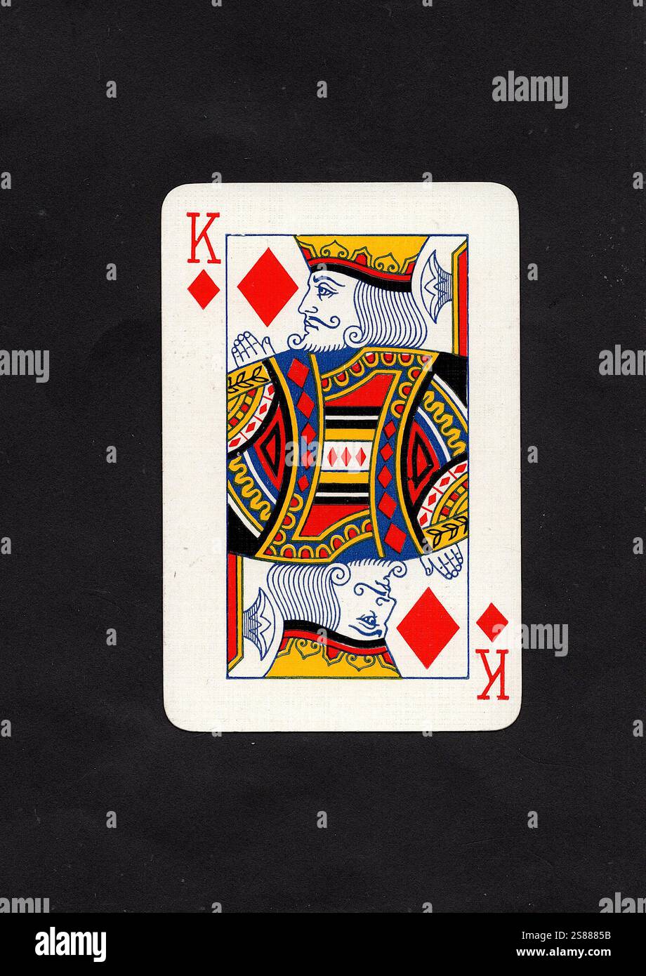 A vintage king of diamonds playing card isolated on a black background ...