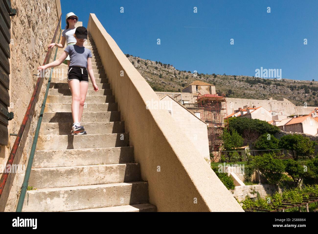 Children / kids climb stone steps / stairs on historic city wall ...