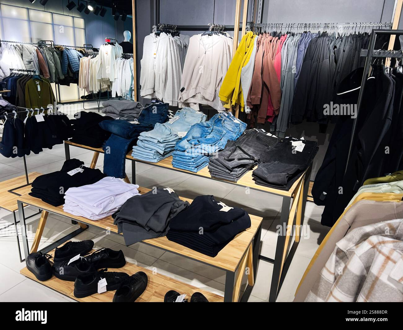 Organized store interior showcasing folded clothes, hanging garments ...