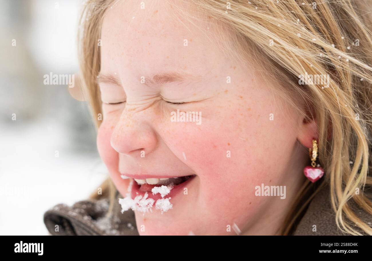 Ella Patterson rects after taking a bite of snow during an icy winter ...