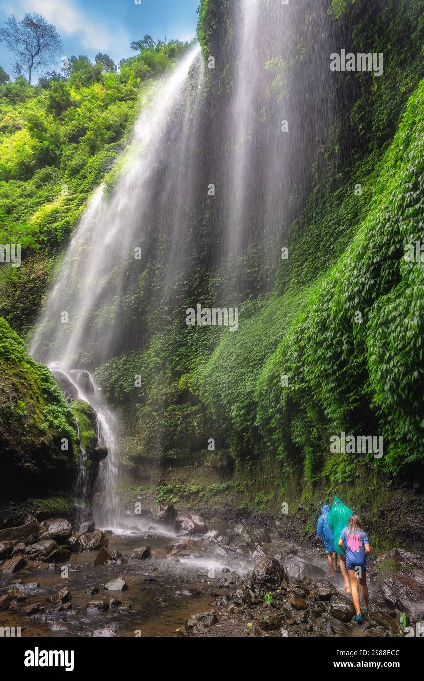 A stunning Madakaripura Waterfall cascades down rocky terrain ...