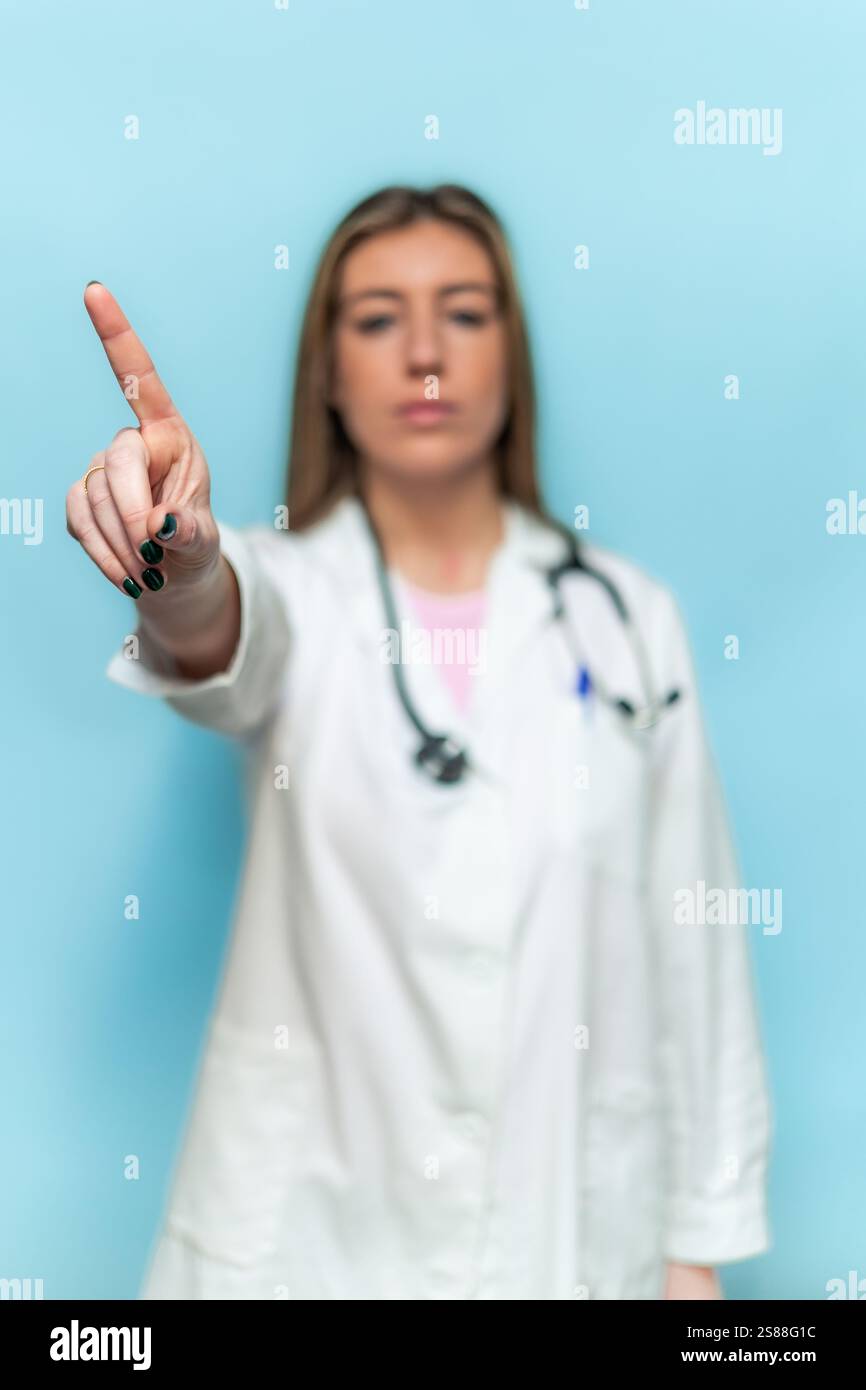 vertical Serious doctor woman making a stop sign with her index finger ...