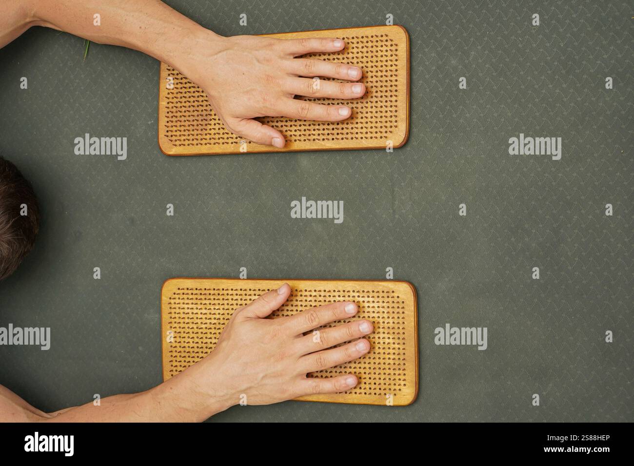 Person's hands on a sadhu board, palms down. The nails in the sadhu ...
