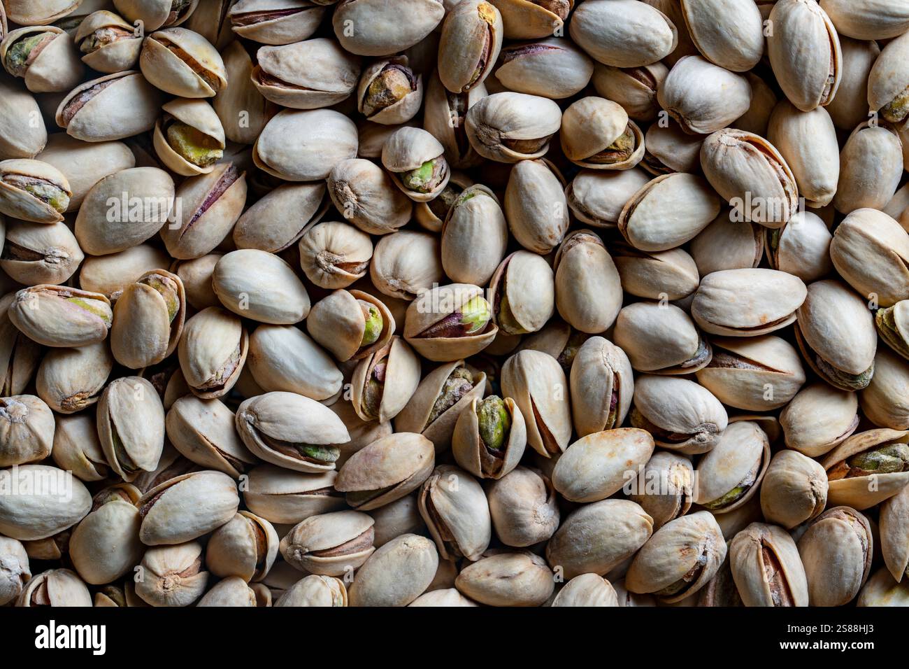 Tasty unpeeled pistachios , top view, close up. Pistachios texture and background. Pile ...