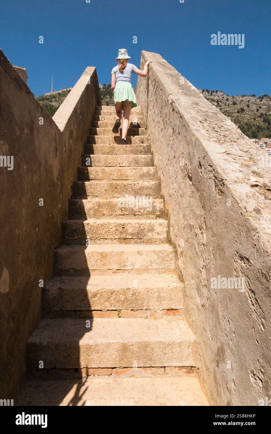 Children / kids climb stone steps / stairs on historic city wall ...