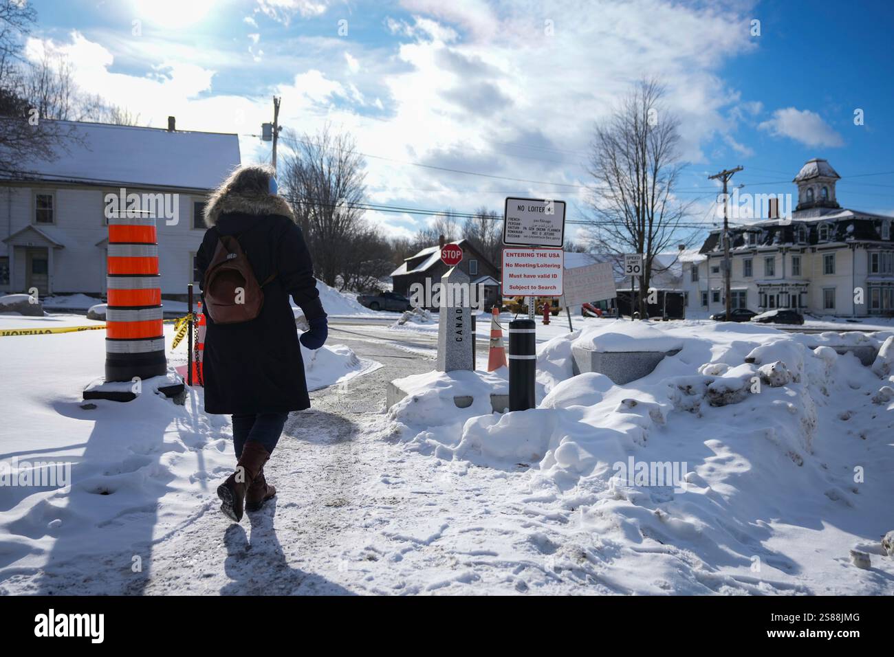 CORRECTS TOWN SPELLING A woman walks up to a border marker leading into ...