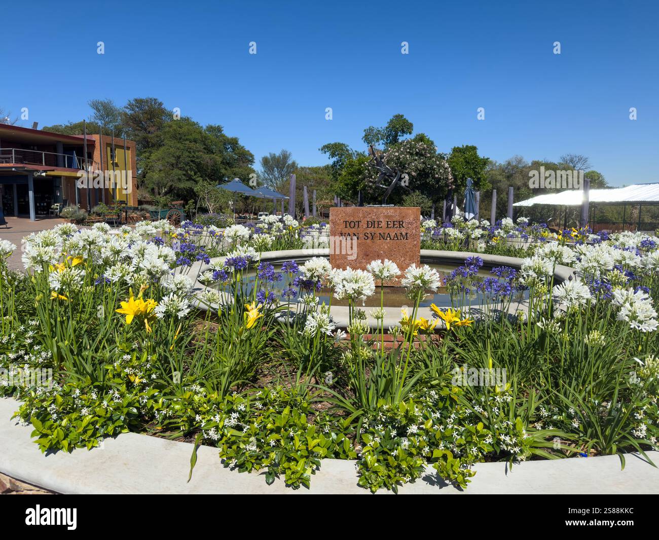 Round water fountain flowers and text sign translation TO THE HONOR OF ...