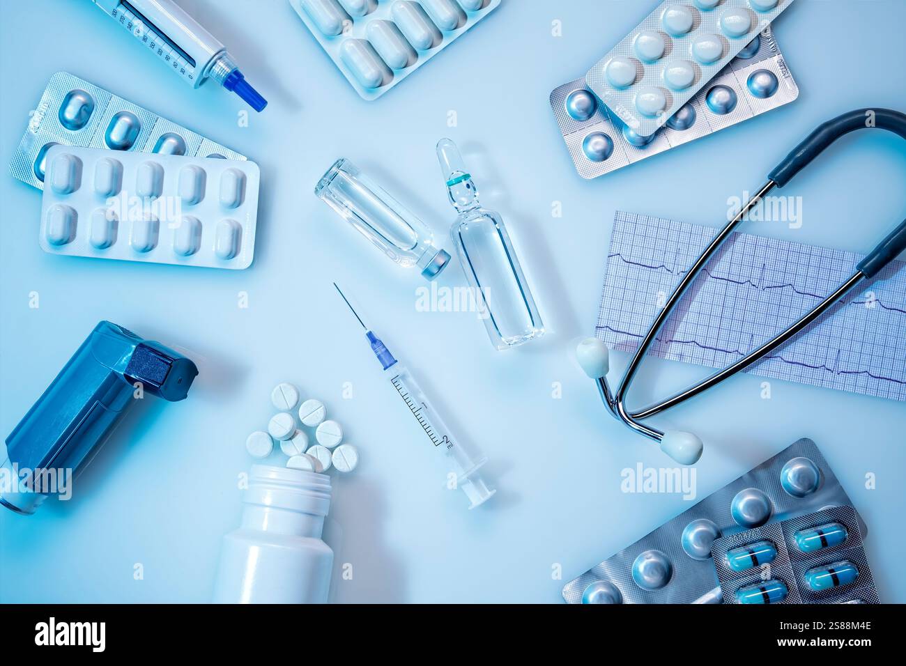 Flat lay with tablets, asthma spray, injectables, syringe and ...
