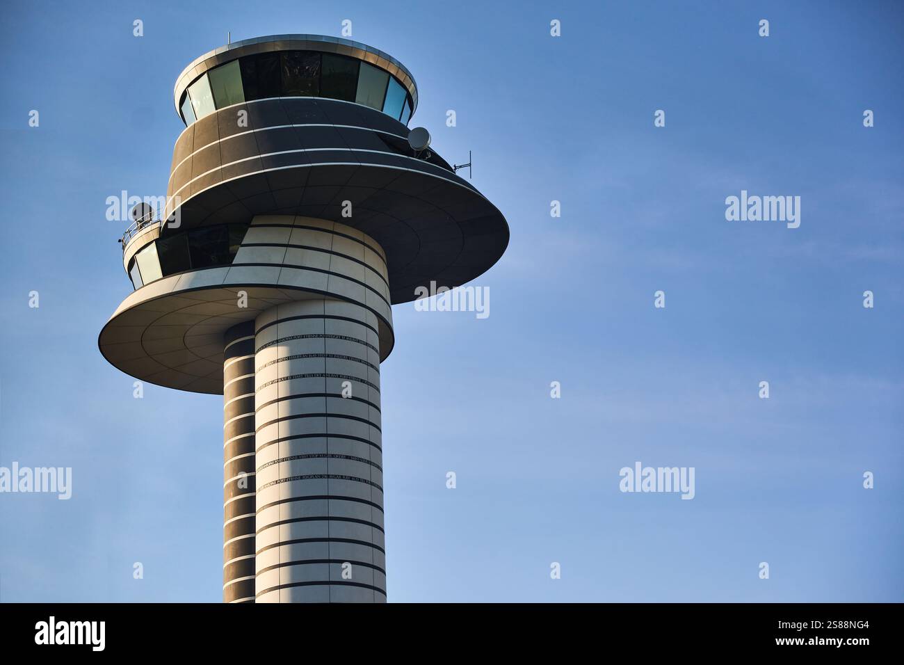A modern air traffic control tower with a cylindrical design and ...
