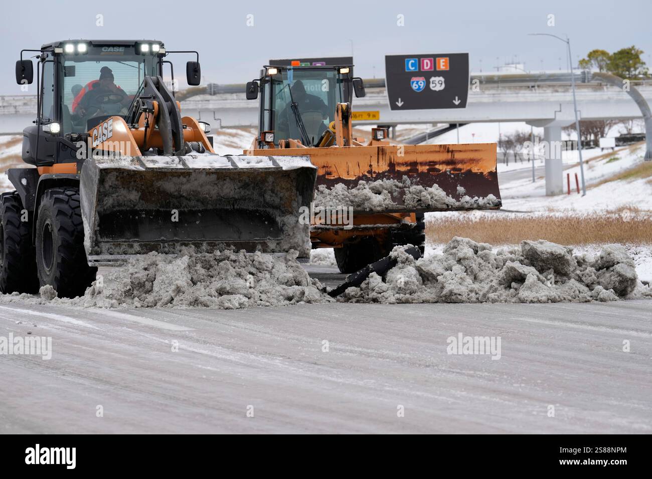 Workers plow snow off the roadways at the closed George Bush ...